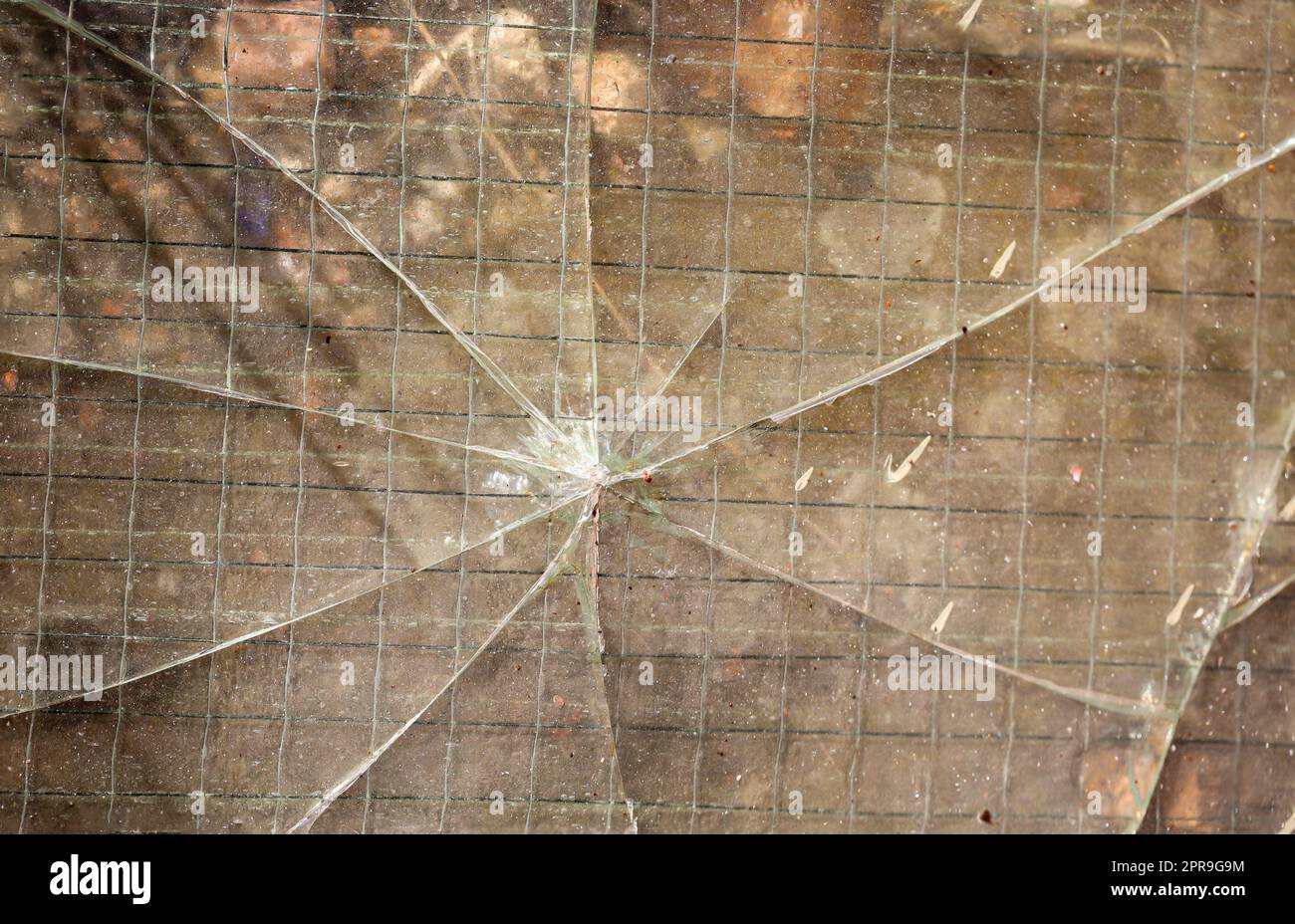 A broken glass with metal grid. Glass breakage texture Stock Photo - Alamy