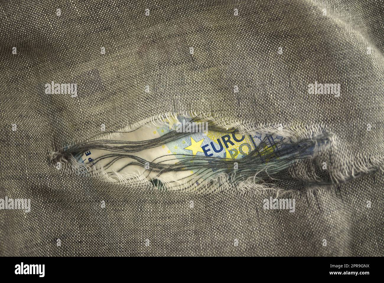 Euro banknote viewed through torn fabric Stock Photo - Alamy