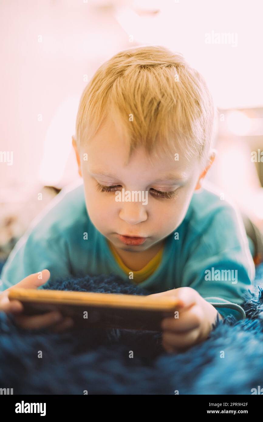 Little Blond Boy Playing Games On Phone Stock Photo - Alamy