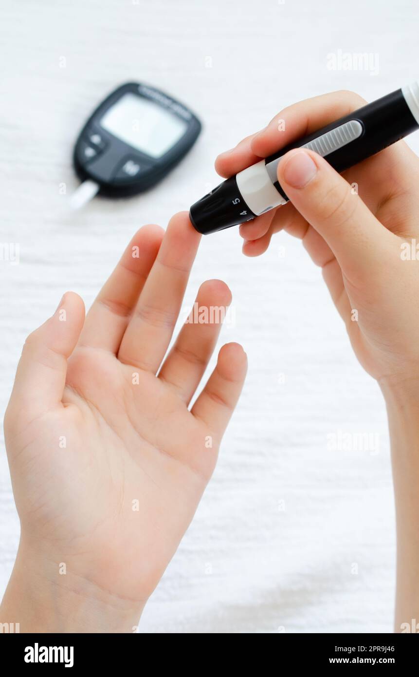 Diabetes checking blood sugar level. Child using lancelet and ...