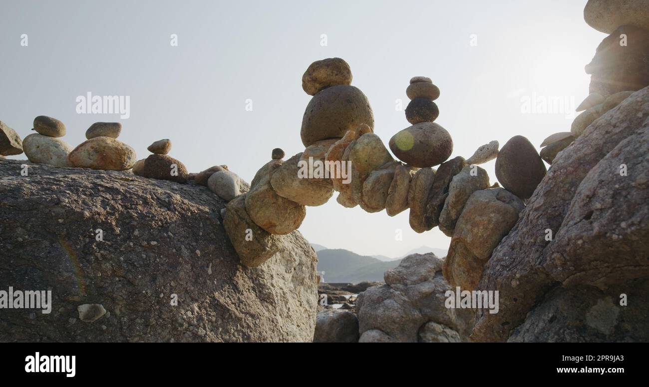 Arch of pebbles in balancing on the sea coast Stock Photo - Alamy