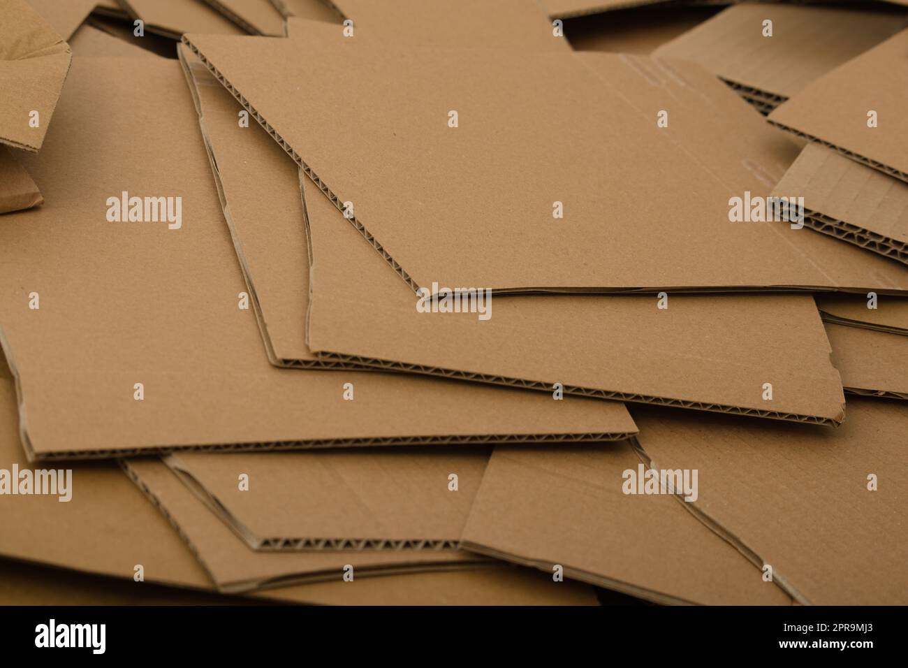 A lot of cut cardboard lying in a large pile. Photo shows the amount of ...