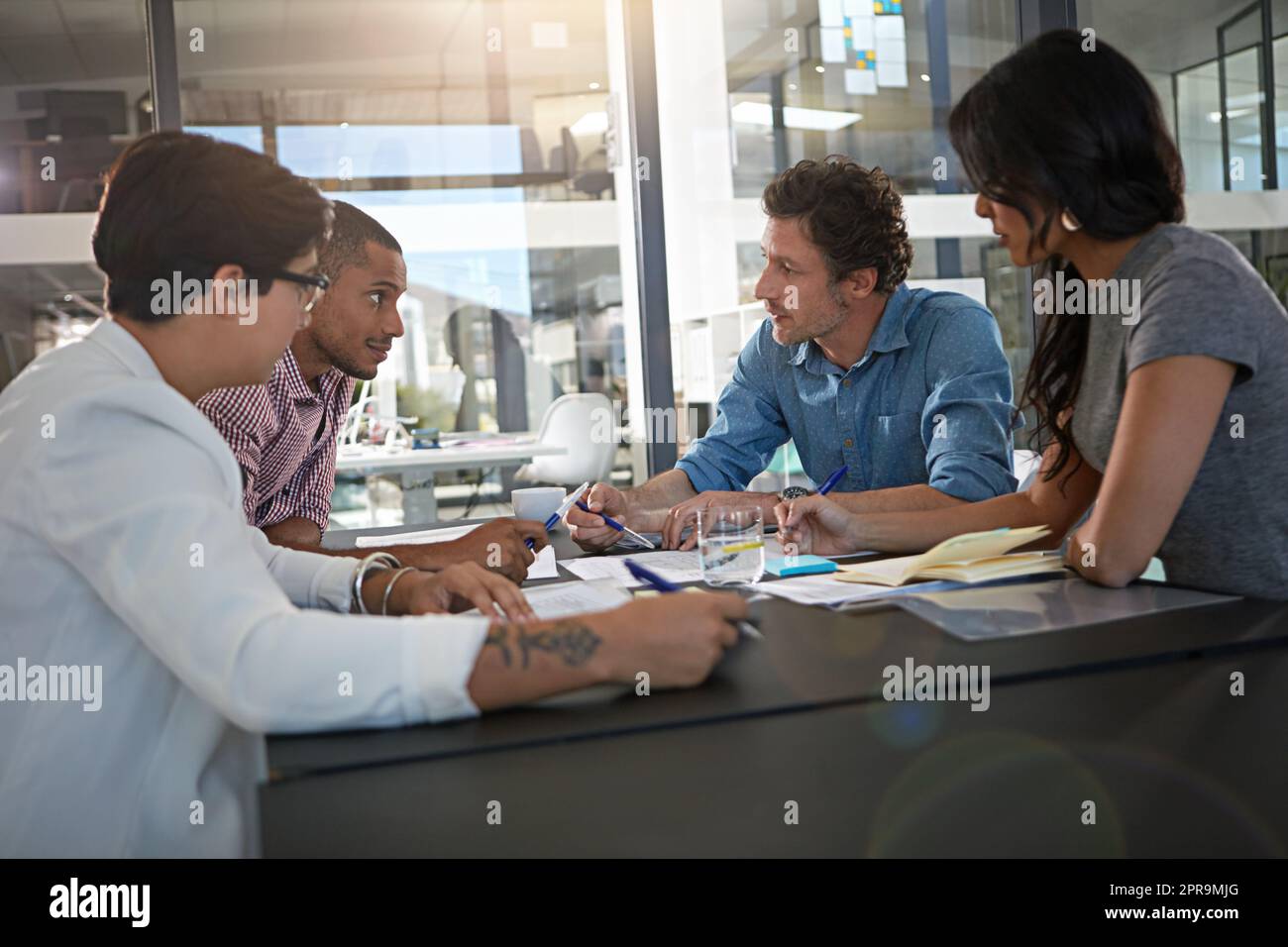 Discussing the way forward. a group of colleagues meeting in the office ...