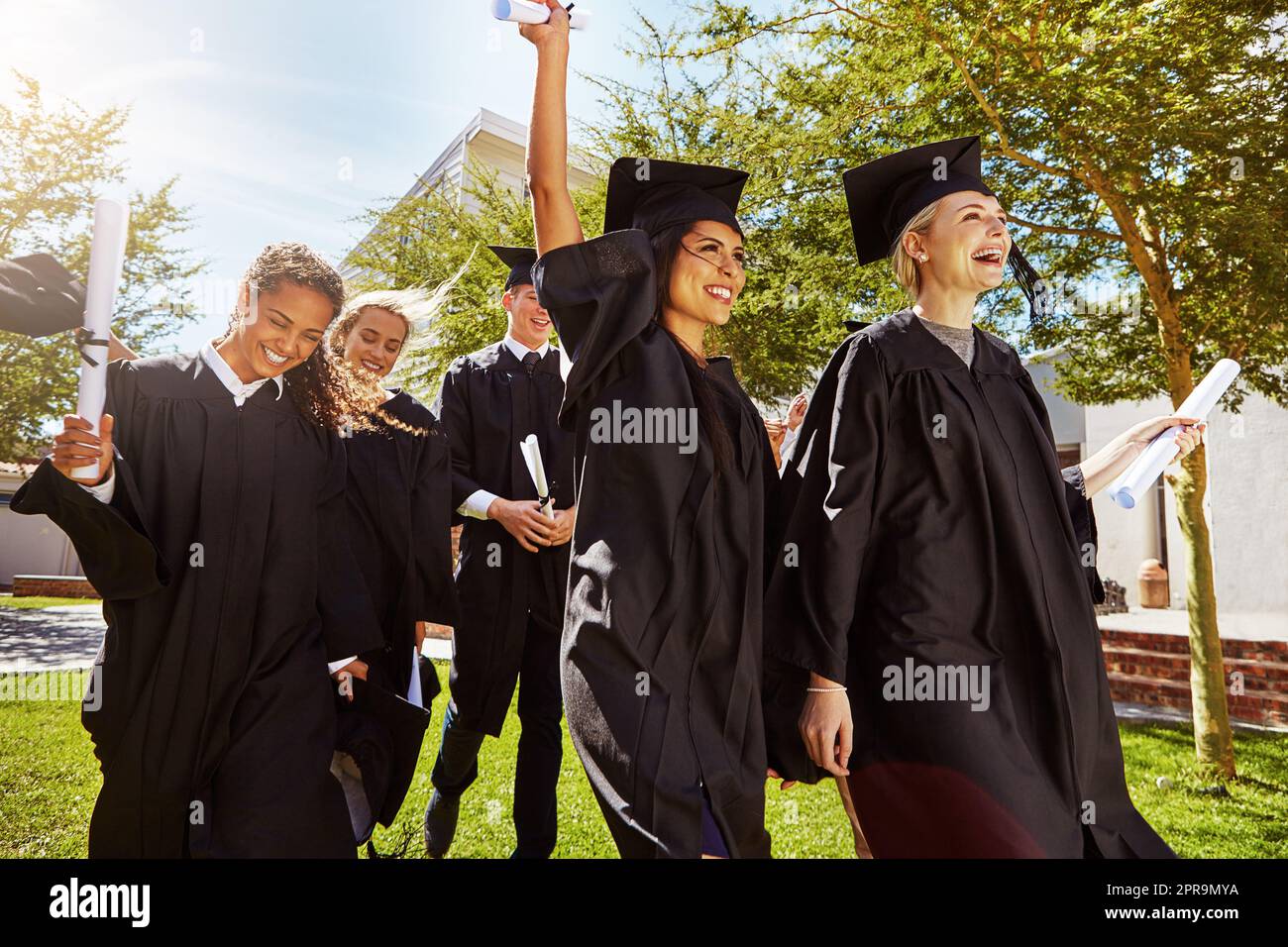 Marching off campus as grads. a group of smiling university students ...