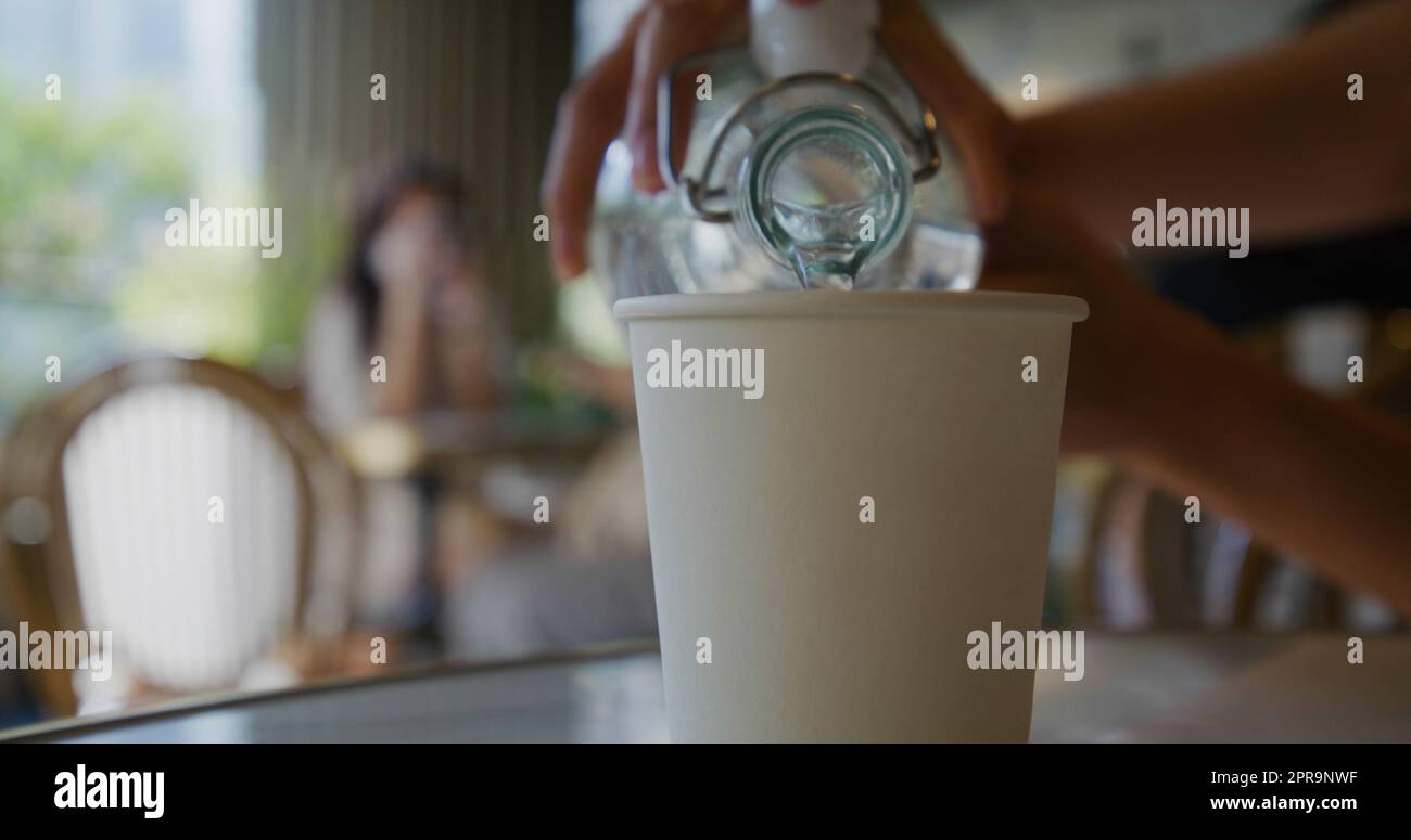 Pour water into paper cup Stock Photo - Alamy