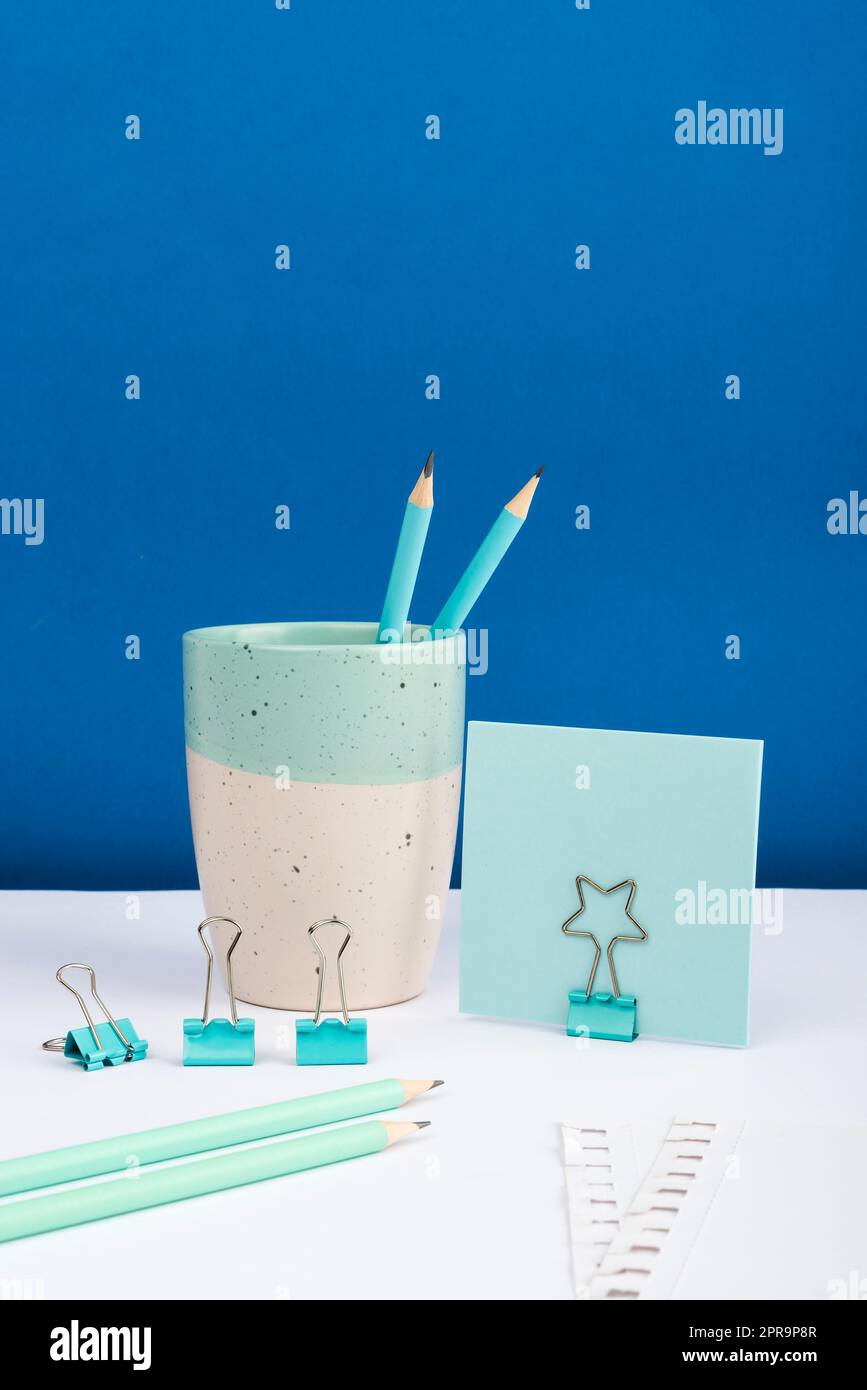 Cup With Pencils And Paperclips Placed On Desk With Clipped Memo With ...