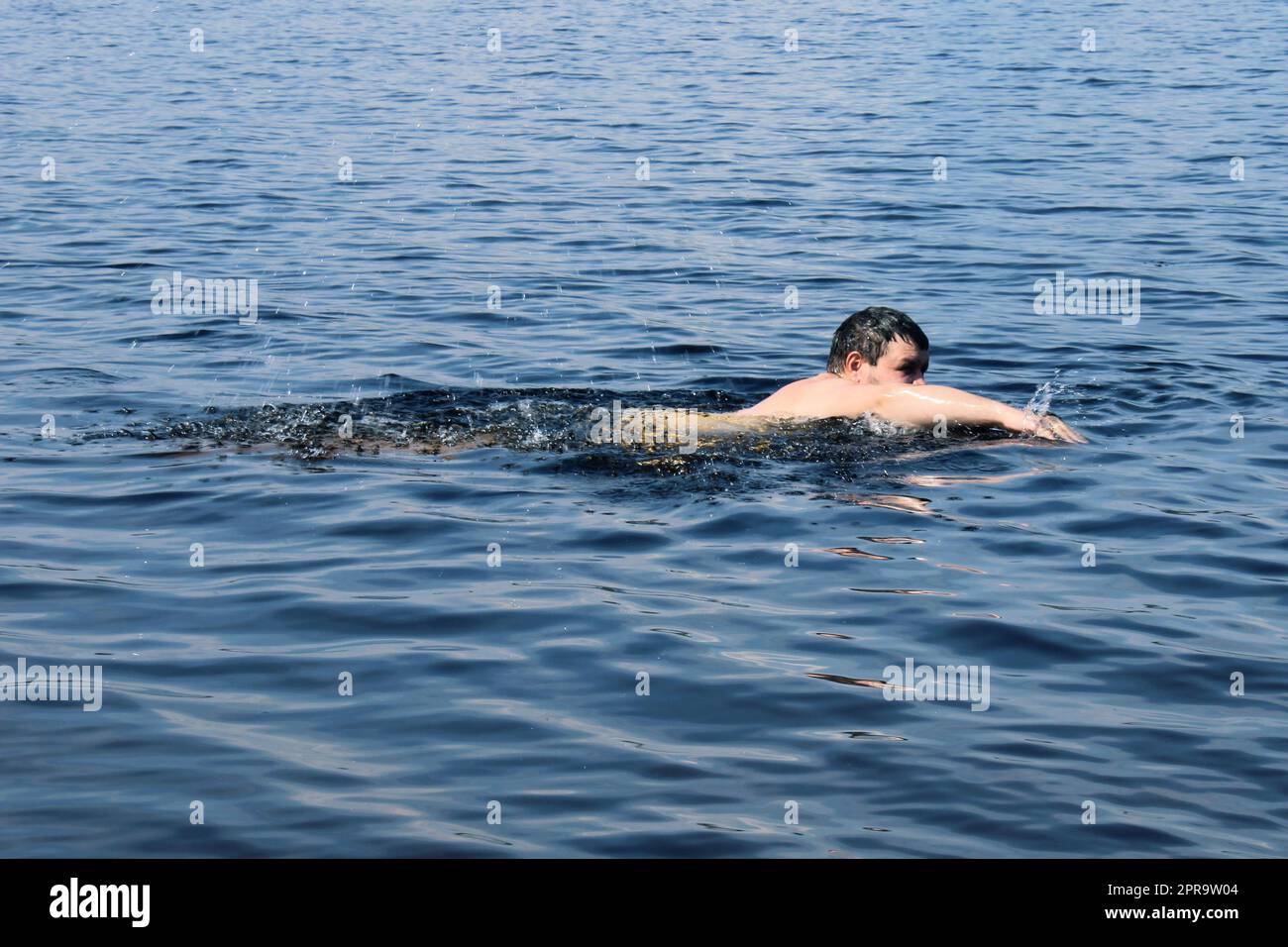 A bearded man swims in the sea. Concept of summer vacation, healthy ...