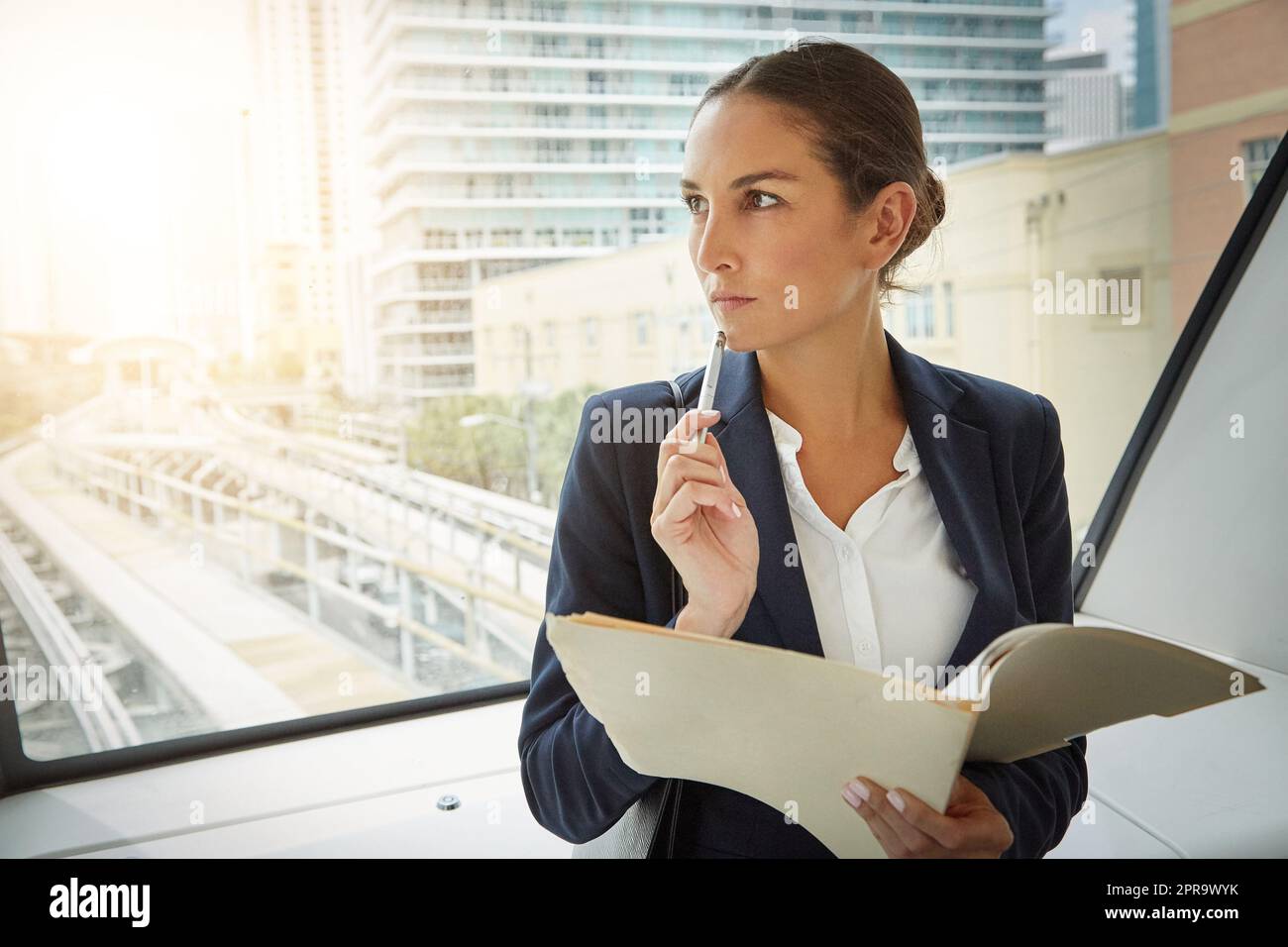 Considering her options. a young businesswoman reading paperwork on her ...