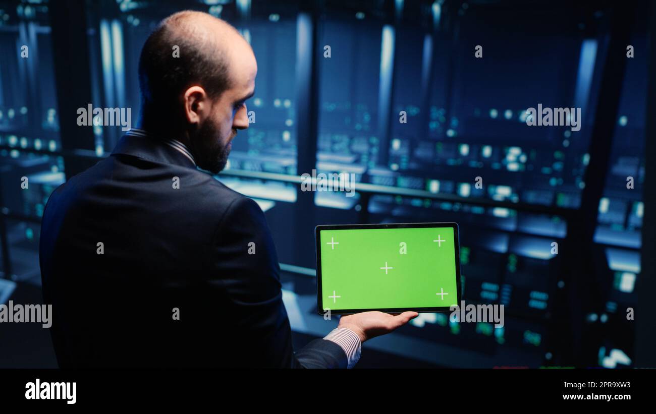 IT administrator running greenscreen display on tablet, using cloud computing in render farm ...
