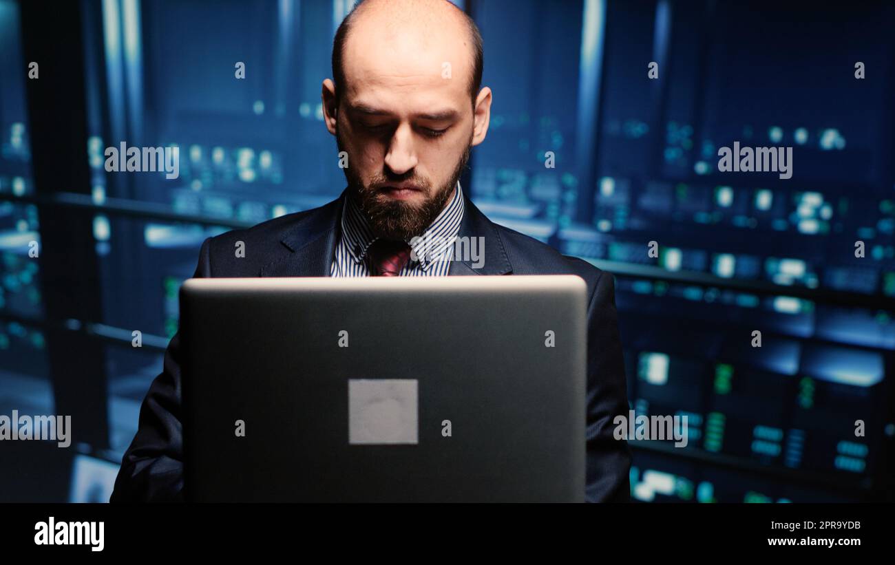 System administrator checking cluster computer service holding laptop ...