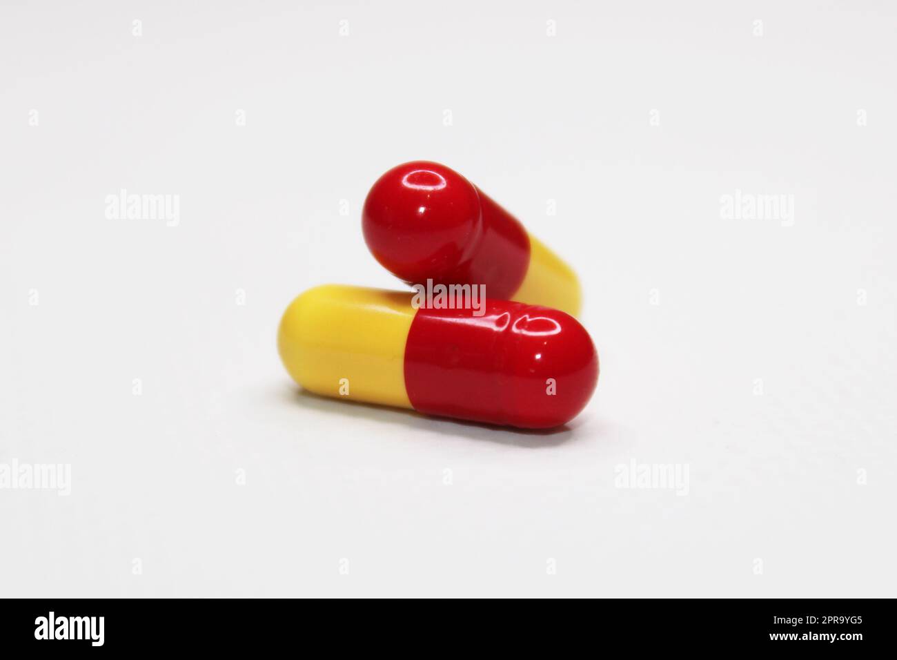 Two medicine capsules close-up on a light background. Health care ...
