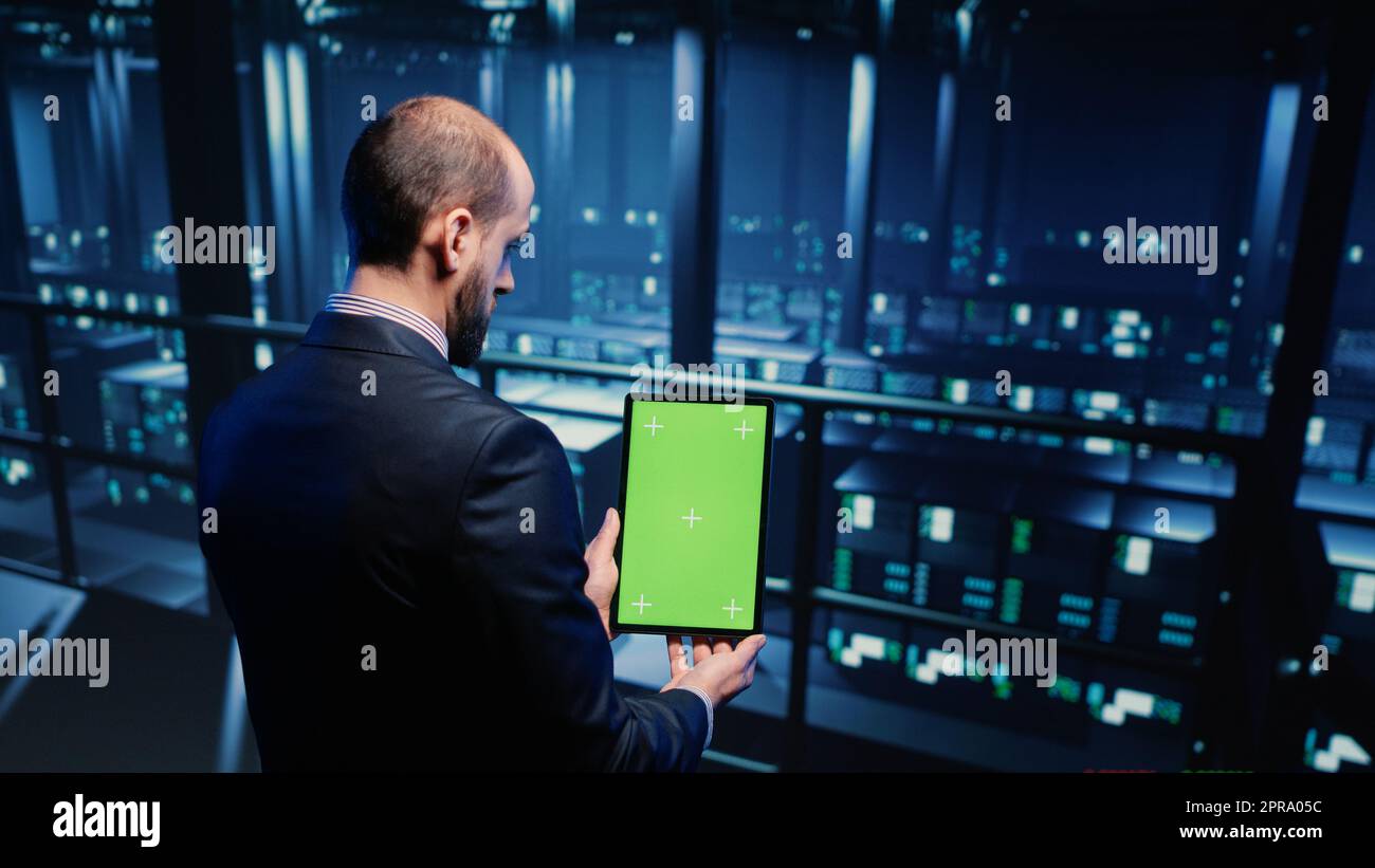 Data center technician holding tablet with green screen in server room ... Data center technician holding tablet with green screen in server room ...