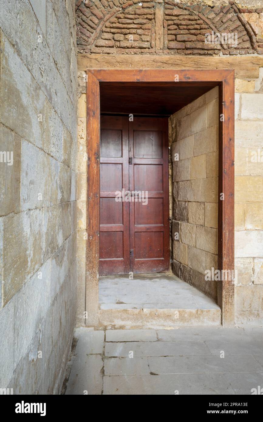 Recessed wooden aged engraved door and stone wall Stock Photo - Alamy