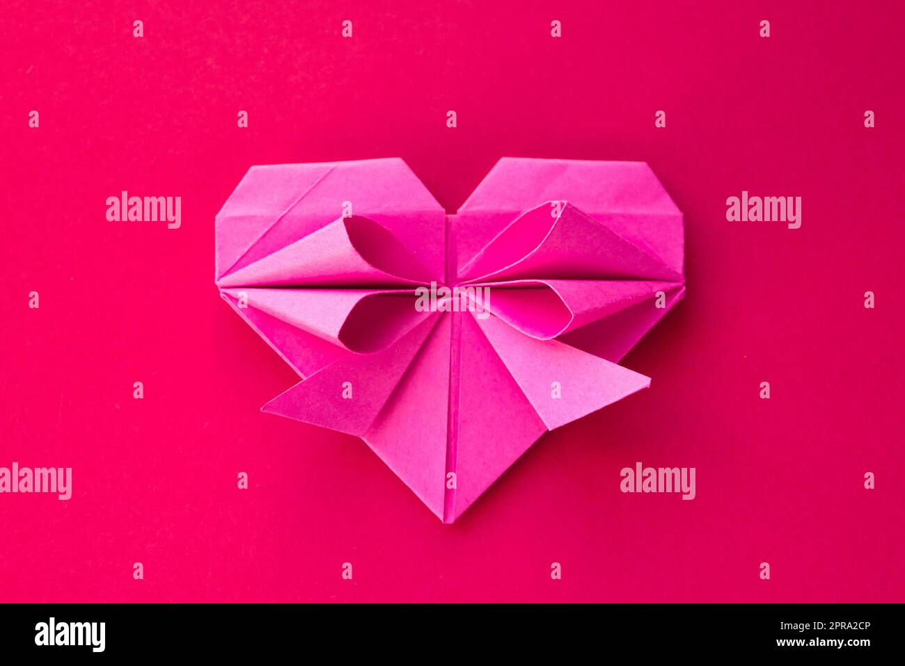 Pink paper heart origami isolated on a red background Stock Photo - Alamy