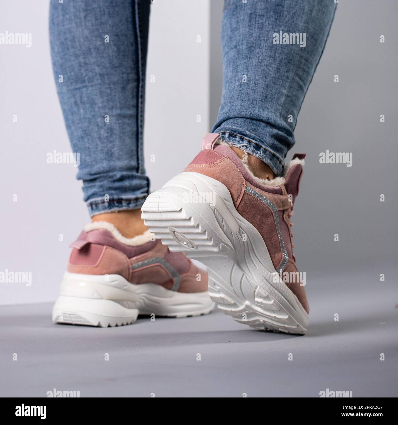 Close up demonstration of rear view of female model in warm sneakers ...