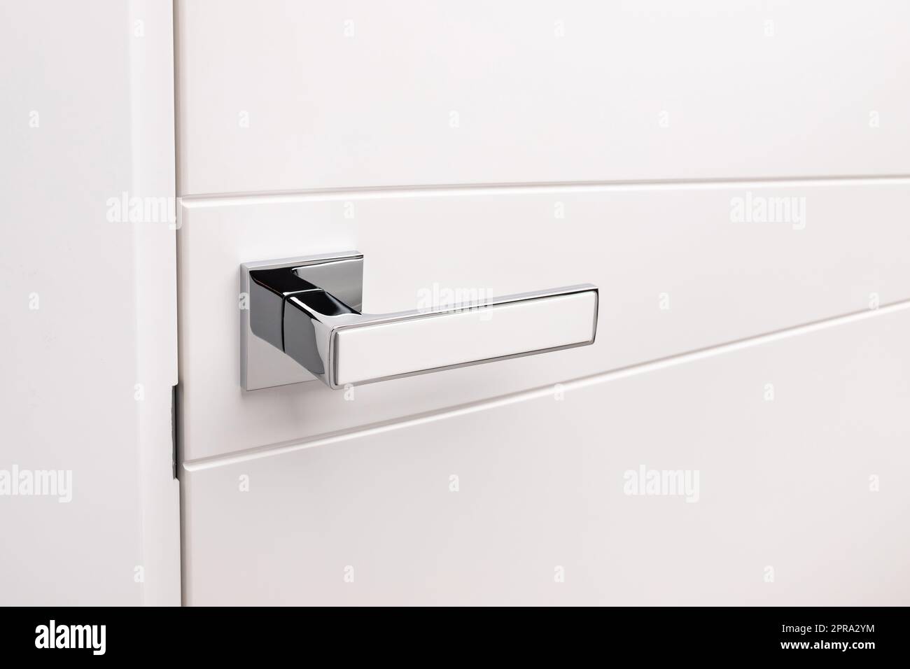 Door handle on white closed doors in modern loft style in interior ...