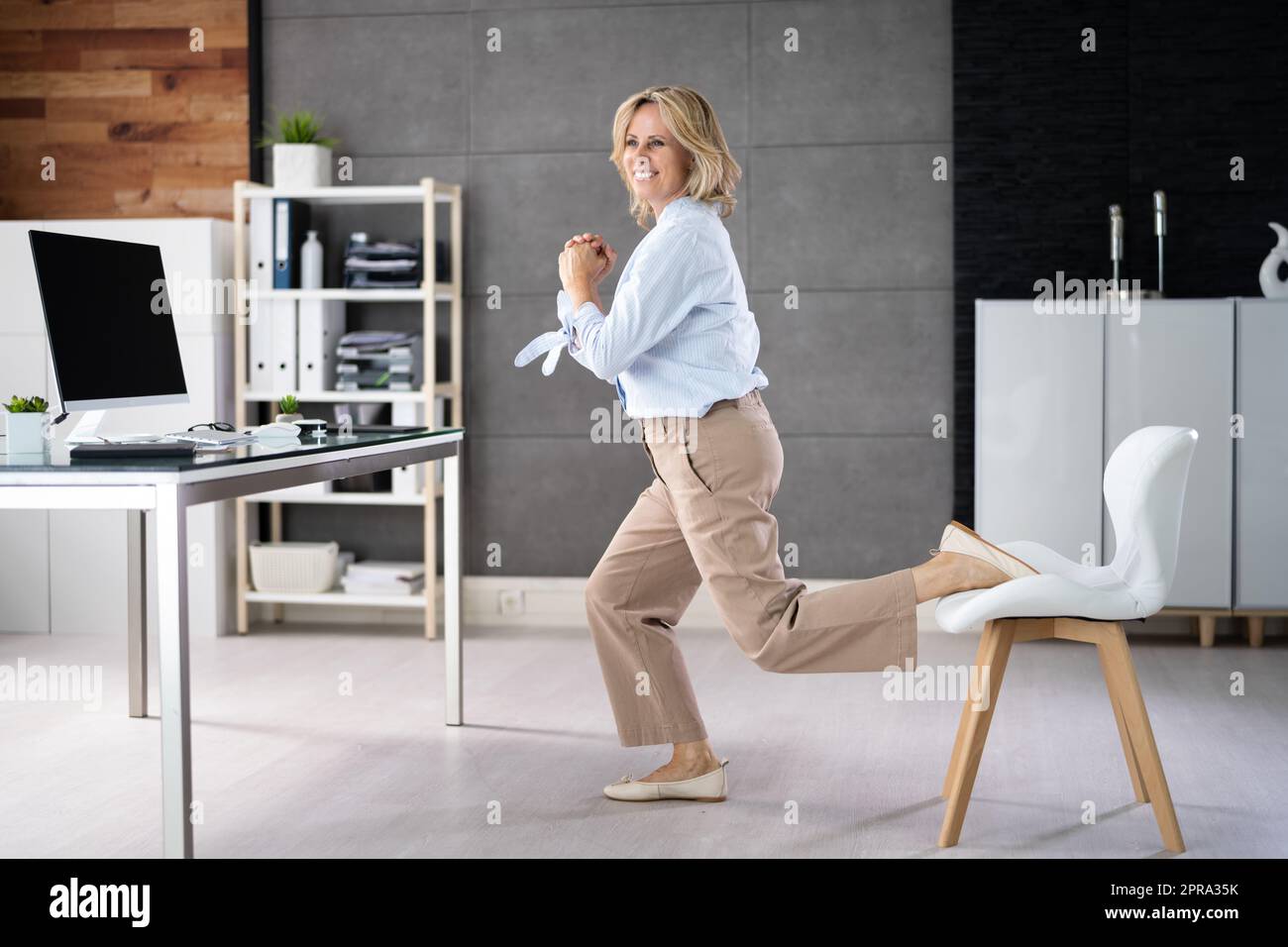 Squat Employee Doing Bulgarian Split Squat Exercise In Office Stock ...