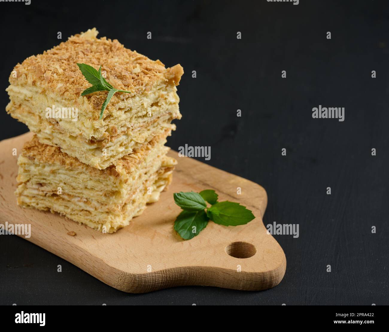 A stack of baked Napoleon pie slices with cream. Puff pastry, delicious ...