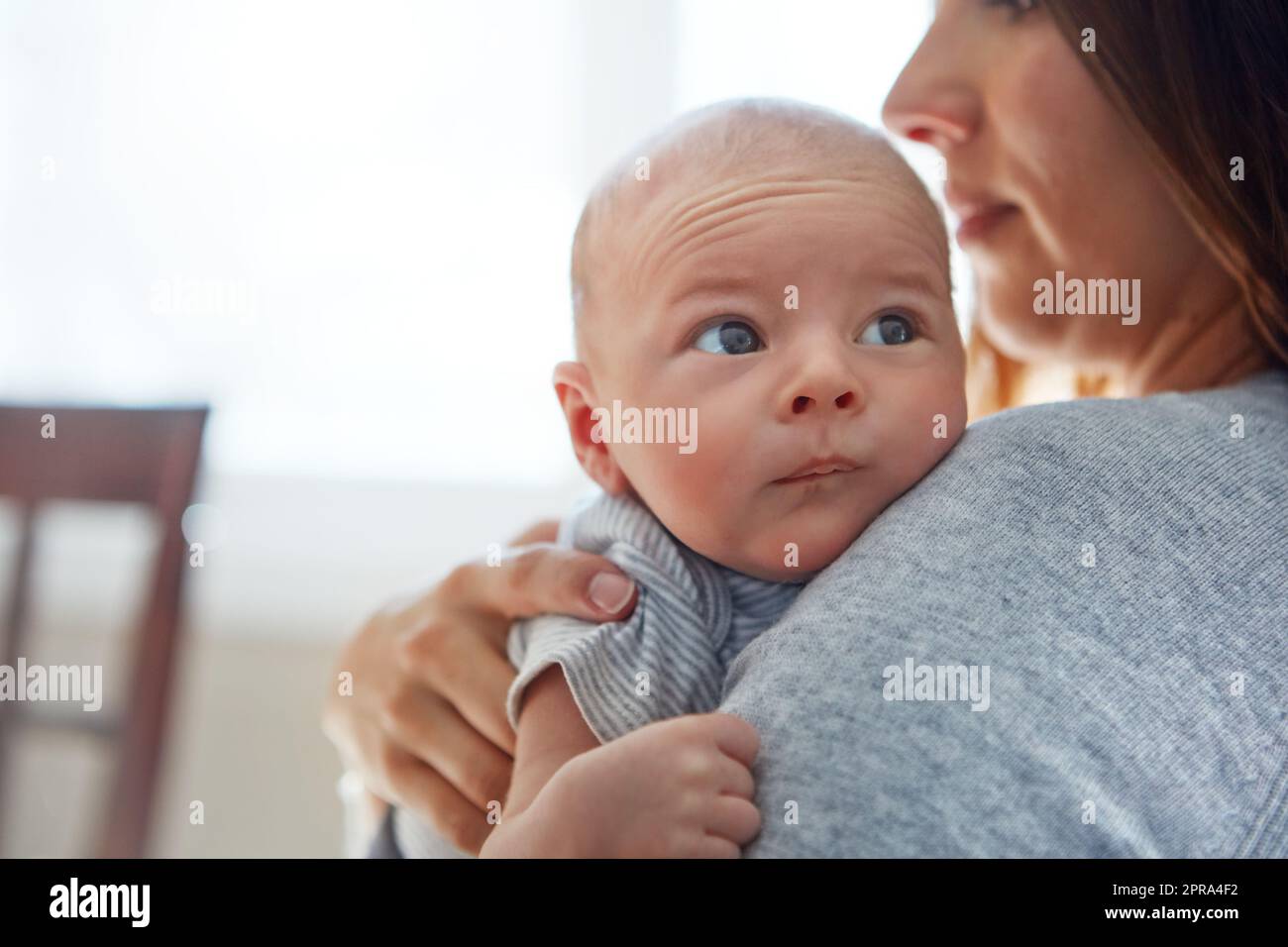Calm and inquisitive. a mother holding her newborn baby Stock Photo - Alamy