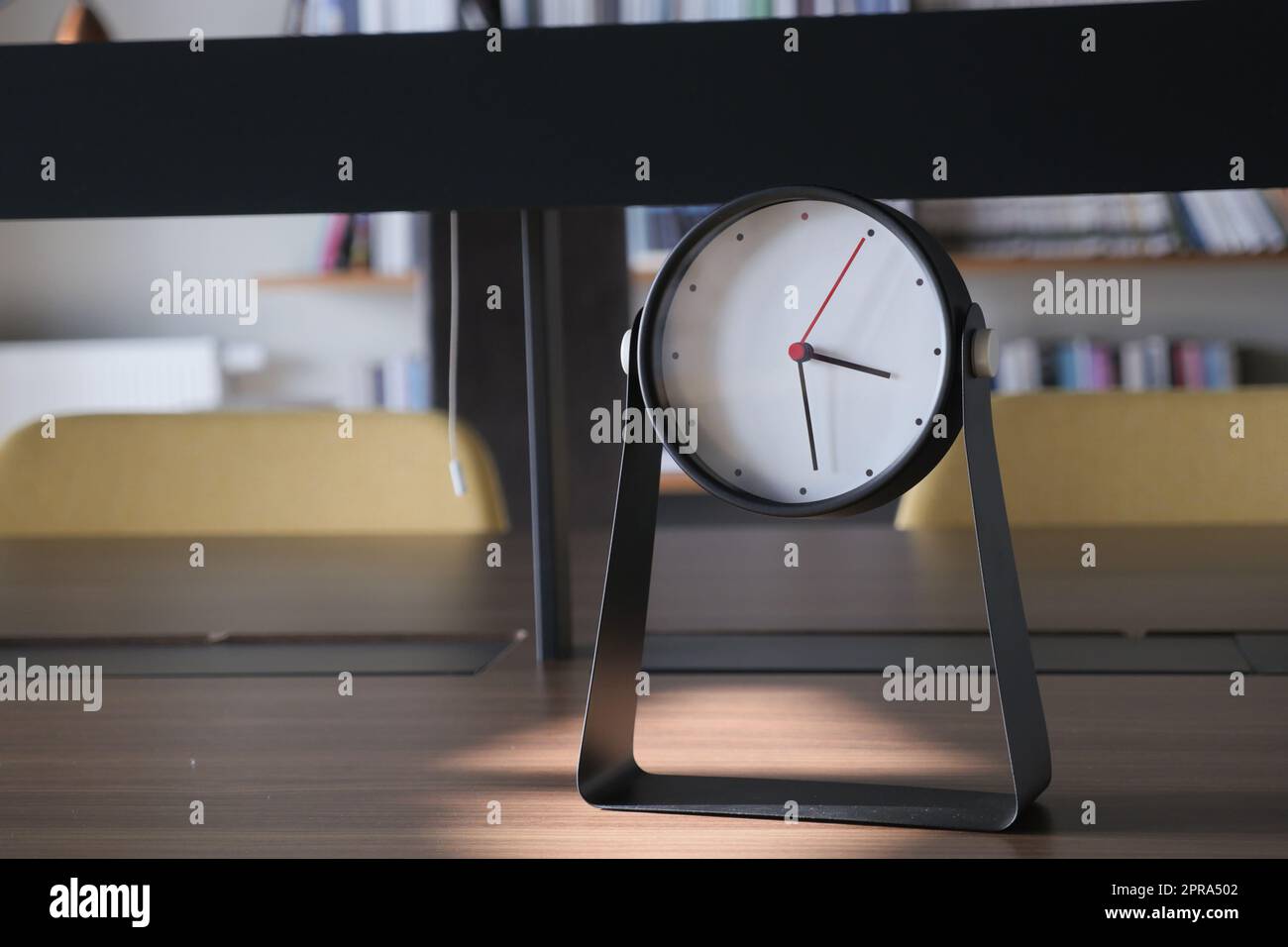 simple modern clock on a book shelf Stock Photo - Alamy