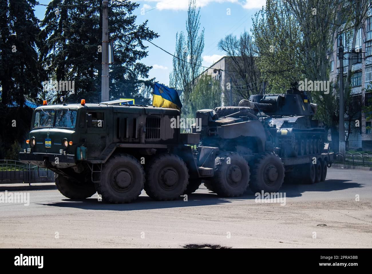 A Ukrainian army truck carries a self-propelled howitzer, a wheeled ...