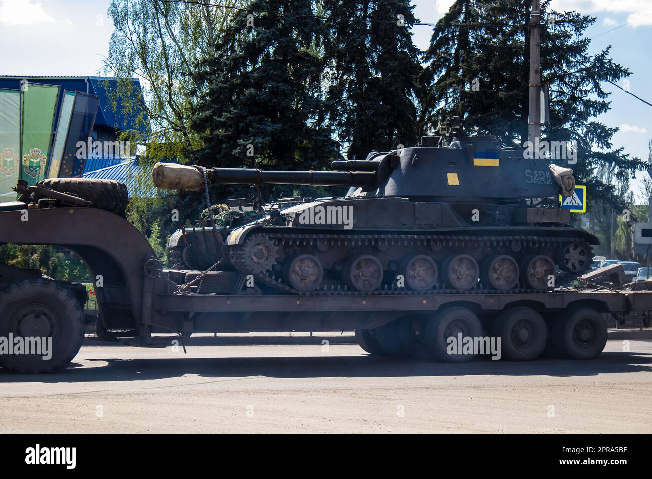 A Ukrainian army truck carries a self-propelled howitzer, a wheeled ...