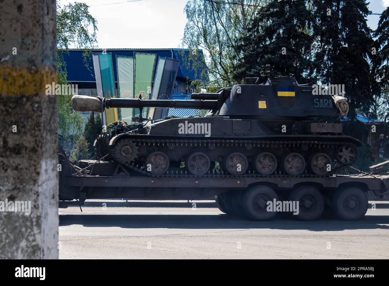 A Ukrainian army truck carries a self-propelled howitzer, a wheeled ...