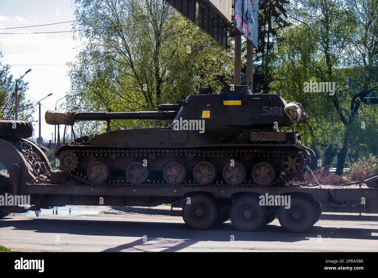 A Ukrainian army truck carries a self-propelled howitzer, a wheeled ...