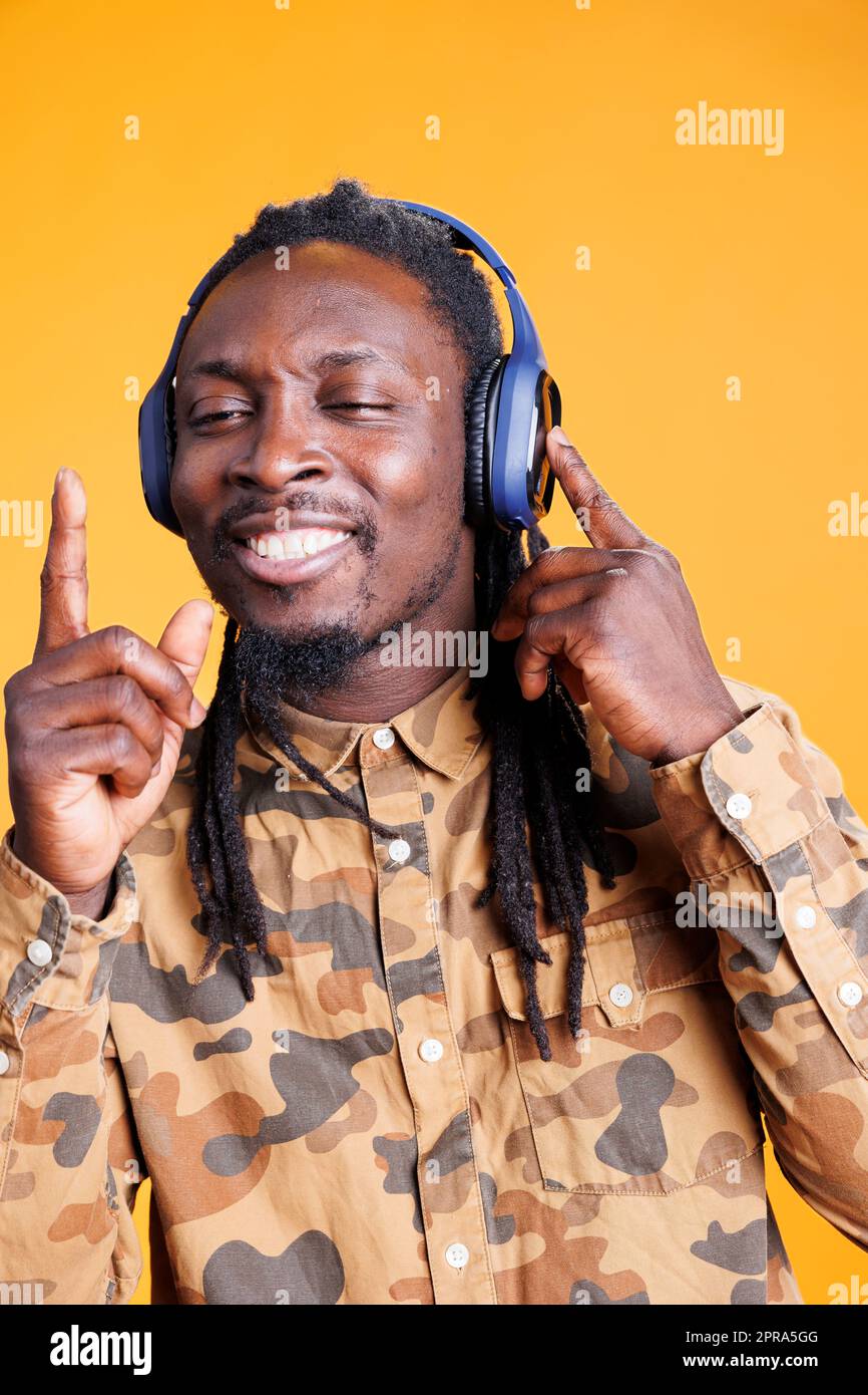 African american person enjoying song audio, wearing headphones while ...