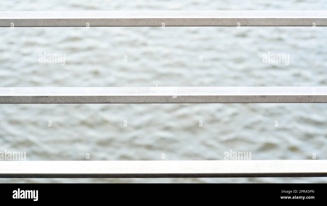 Metal railing barrier bars and moving water background, river bank, sea ...