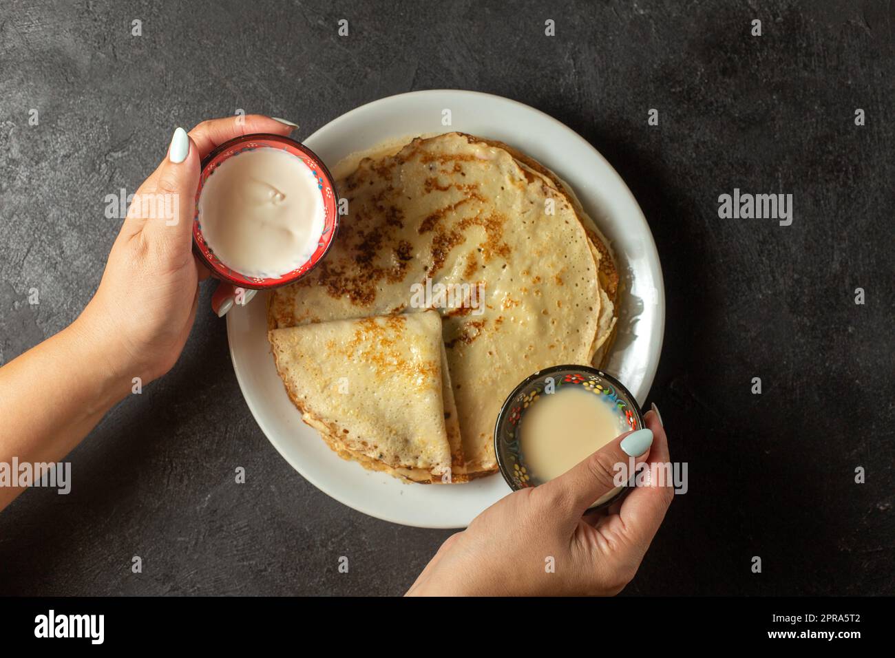 top view little baked pancakes with milk inside white plate on the dark ...