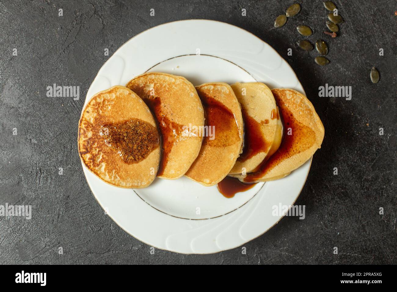 top view sauced pancakes with caramel inside white plate on the dark ...