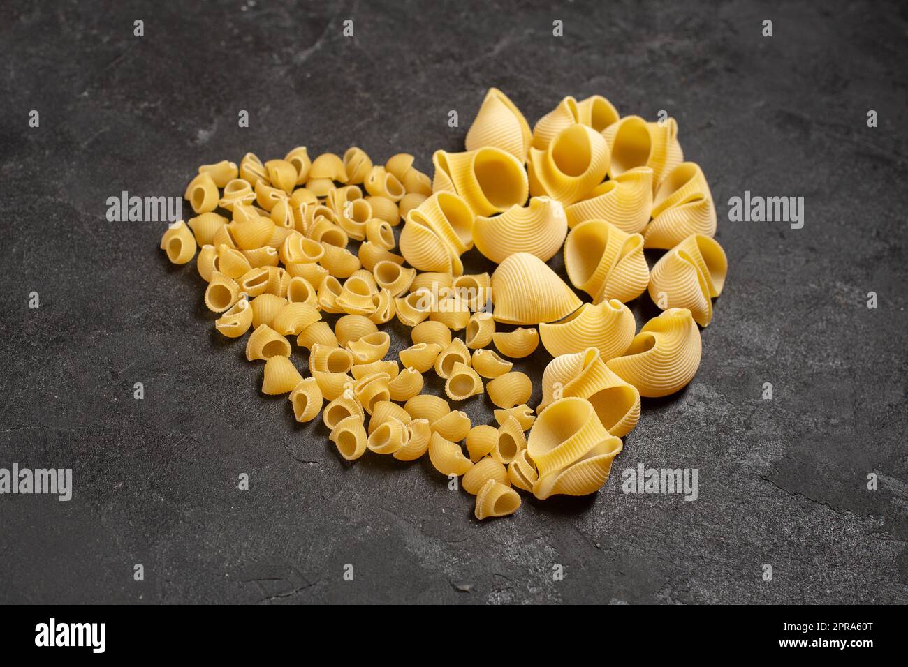 front view raw italian pasta yellow colored little formed raw on the ...