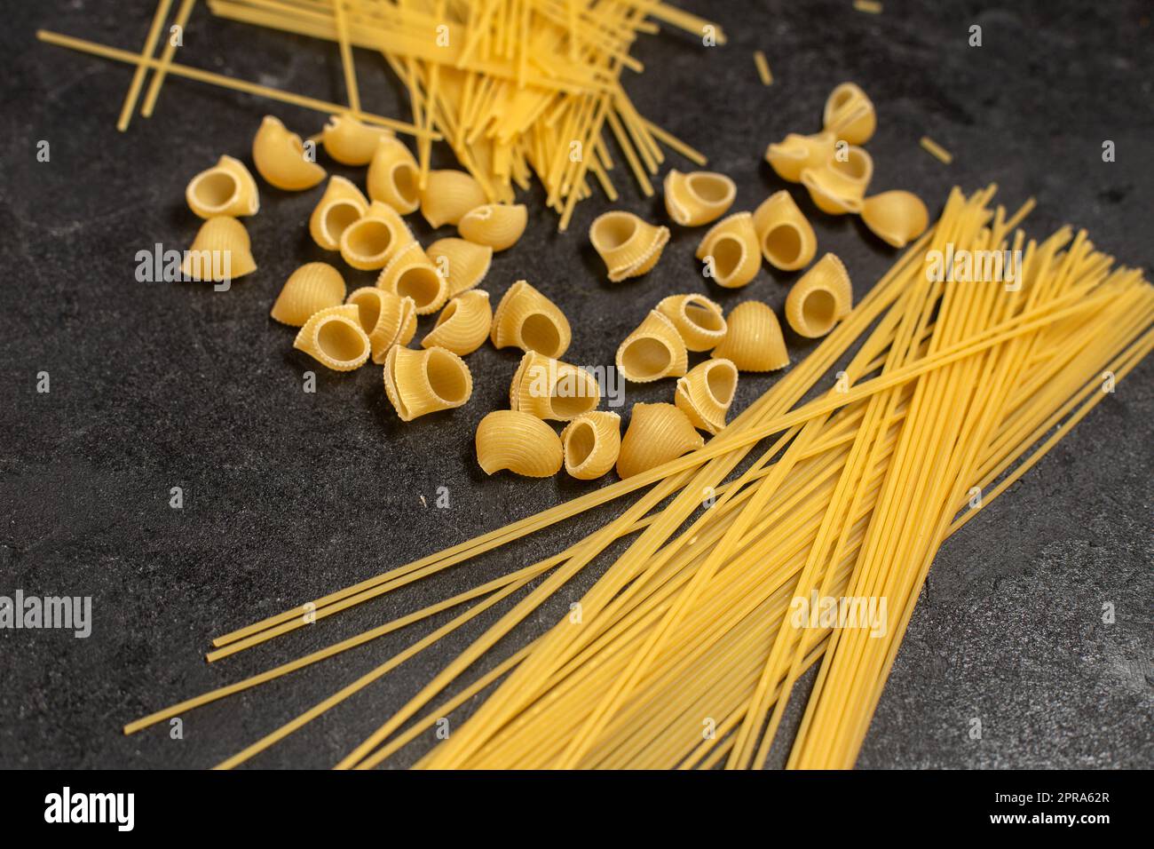 top close view raw italian pasta long and little formed on the dark ...