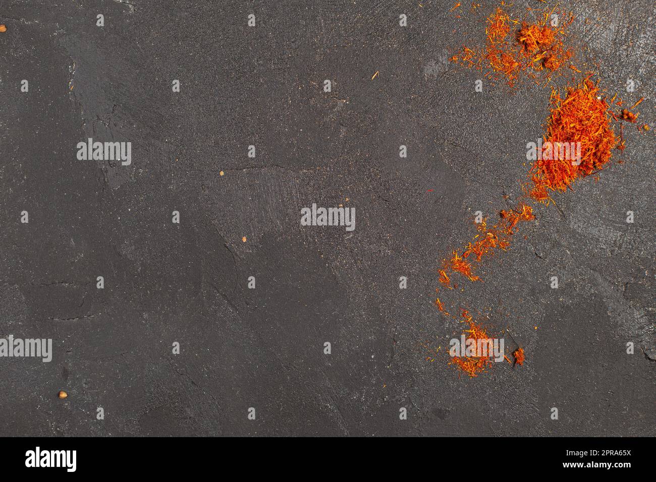 top view orange seasoning powder formed on the dark background spice ...