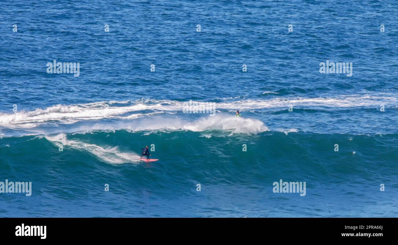 Riding on huge waves in Nazare next to Fort . Rider in distance (maybe ...