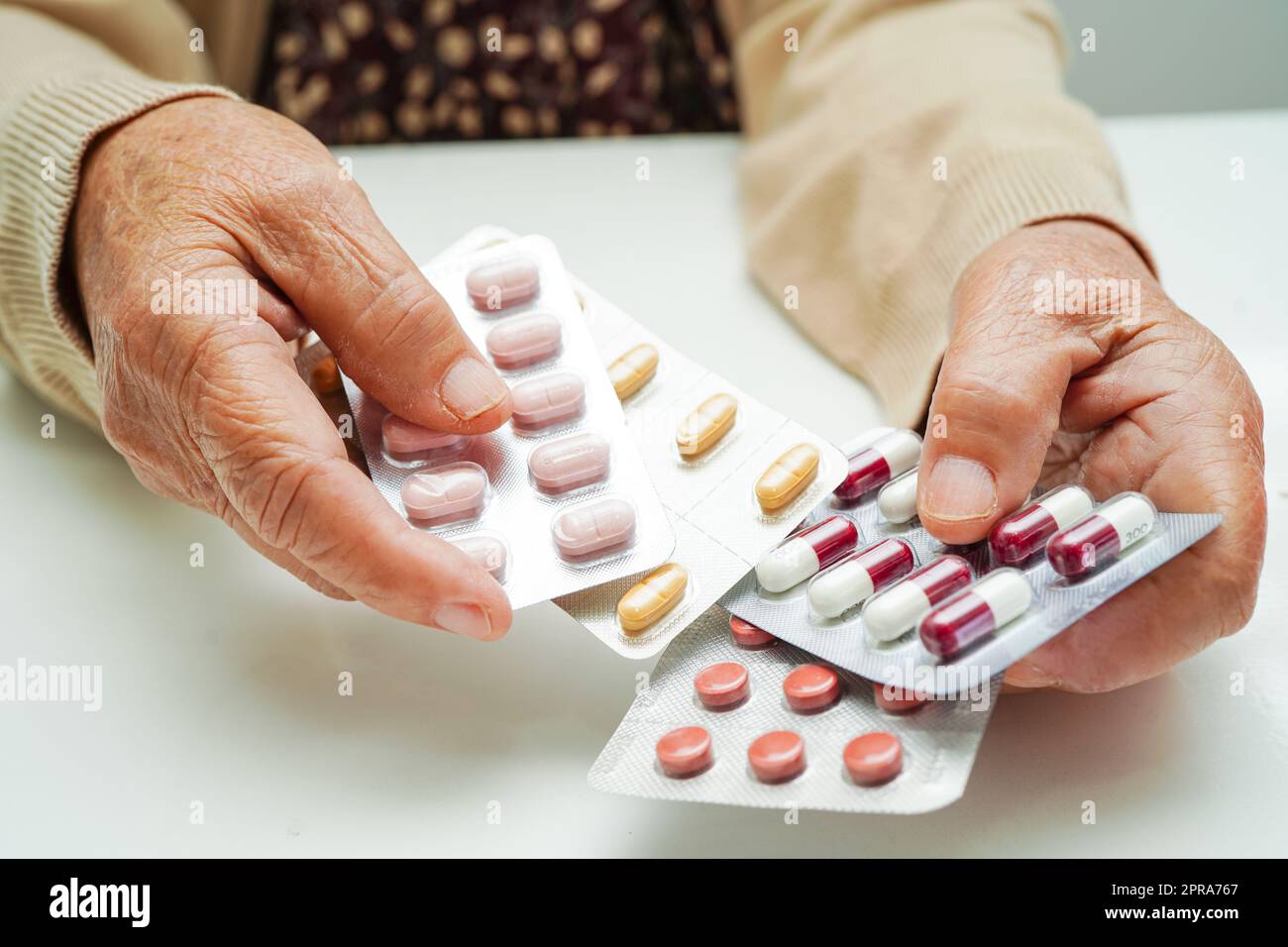 Asian elderly woman holding pill drug in hand, strong healthy medical ...