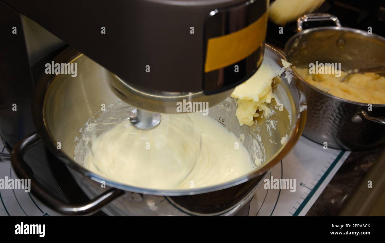male hands add the ingredient cream for baking in the bowl of a food ...