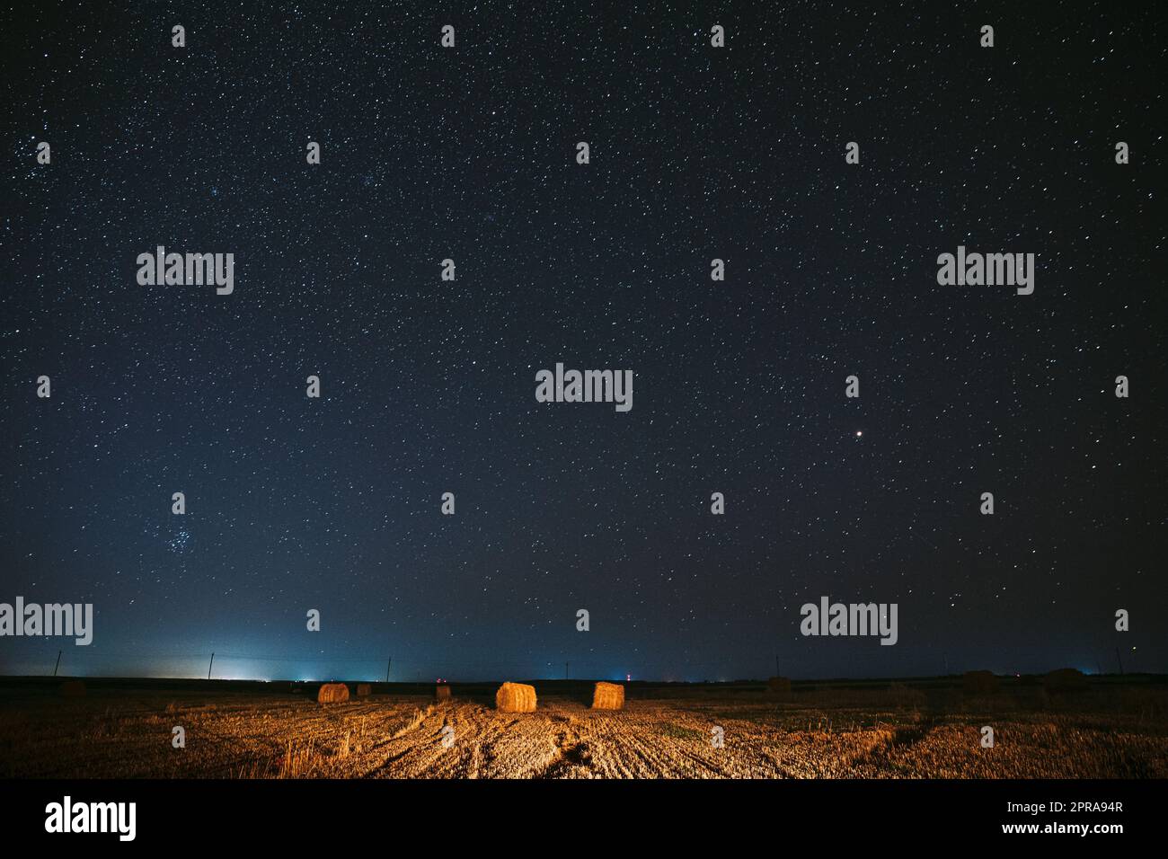 Night Starry Sky Above Haystacks In Summer Agricultural Field. Night ...