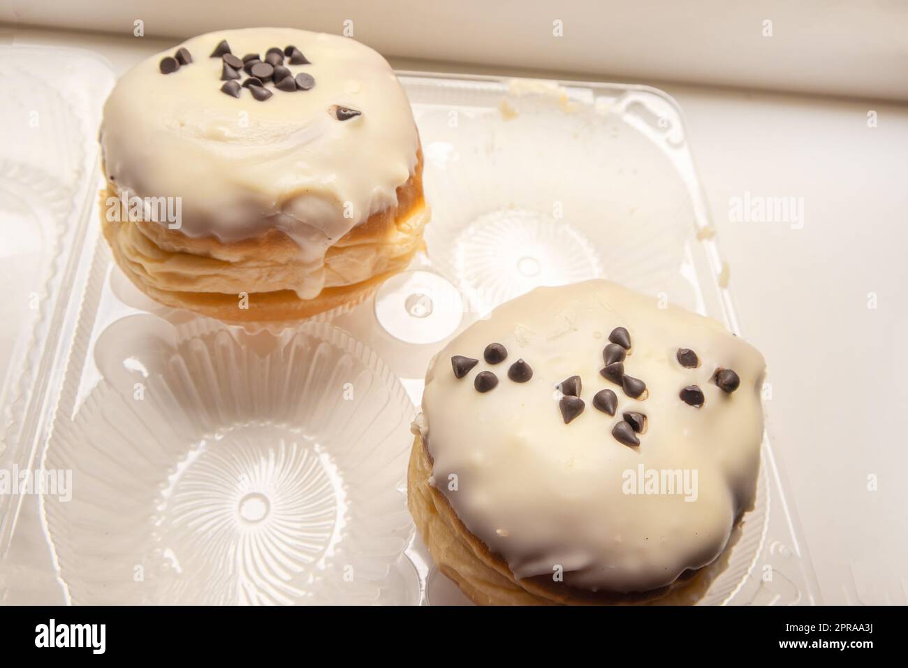 Two delicious donuts with icing sugar and chocolate chips on a white ...