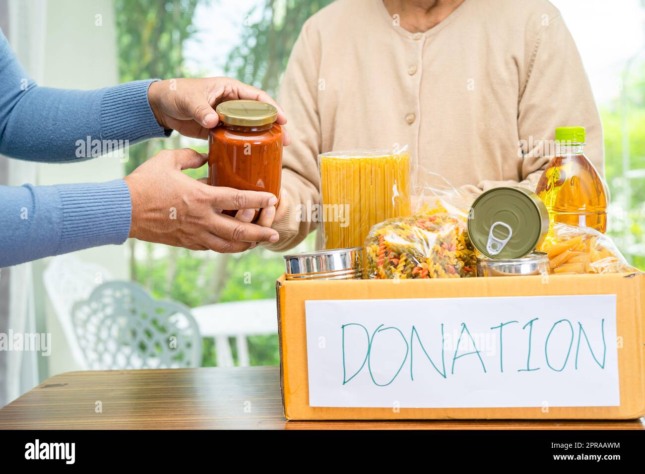 Volunteers putting various dry food in donation box for help people ...