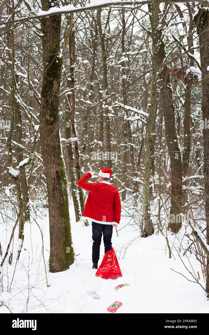 Traditional Santa Claus wearing a hat and dragging a big red sack with ...