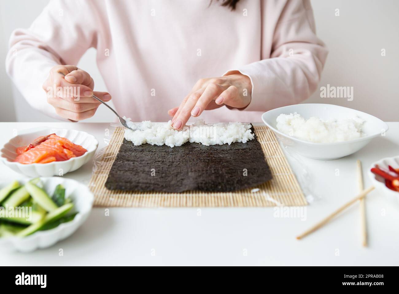 Sushi cooking process, girl makes sushi with different flavors Stock ...