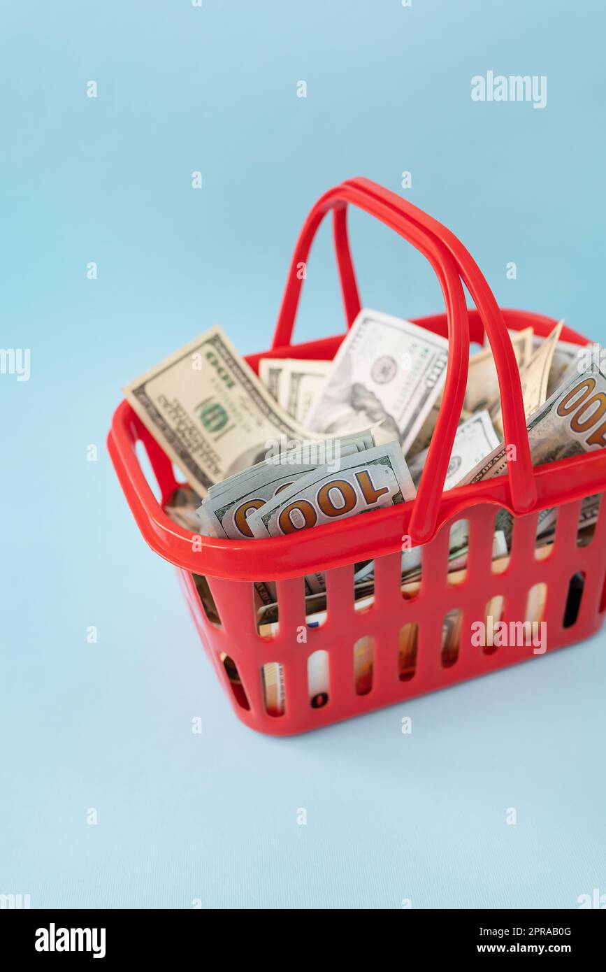 Red grocery cart with many 100 dollar bills inside. The concept of ...