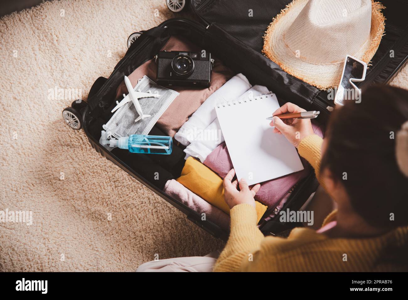 Woman writing paper take note and packing suitcase to vacation writing ...
