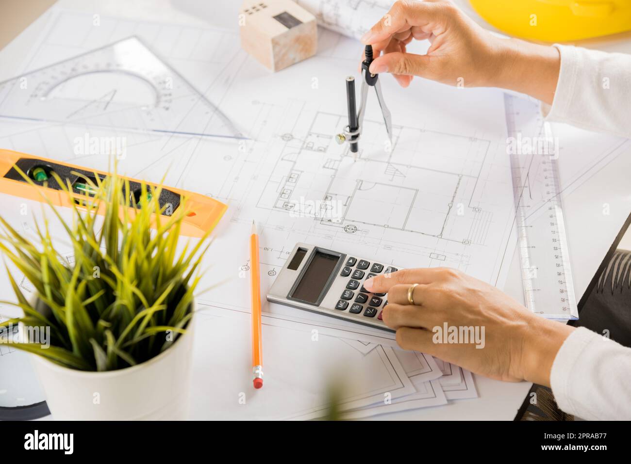 Architect drawing with divider compass on house plan blueprint paper ...