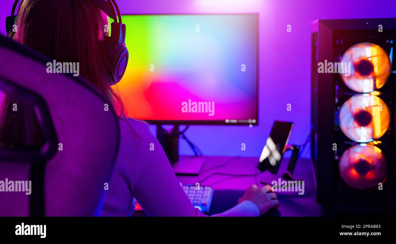 Asian professional gamer playing online video game on desktop computer ...