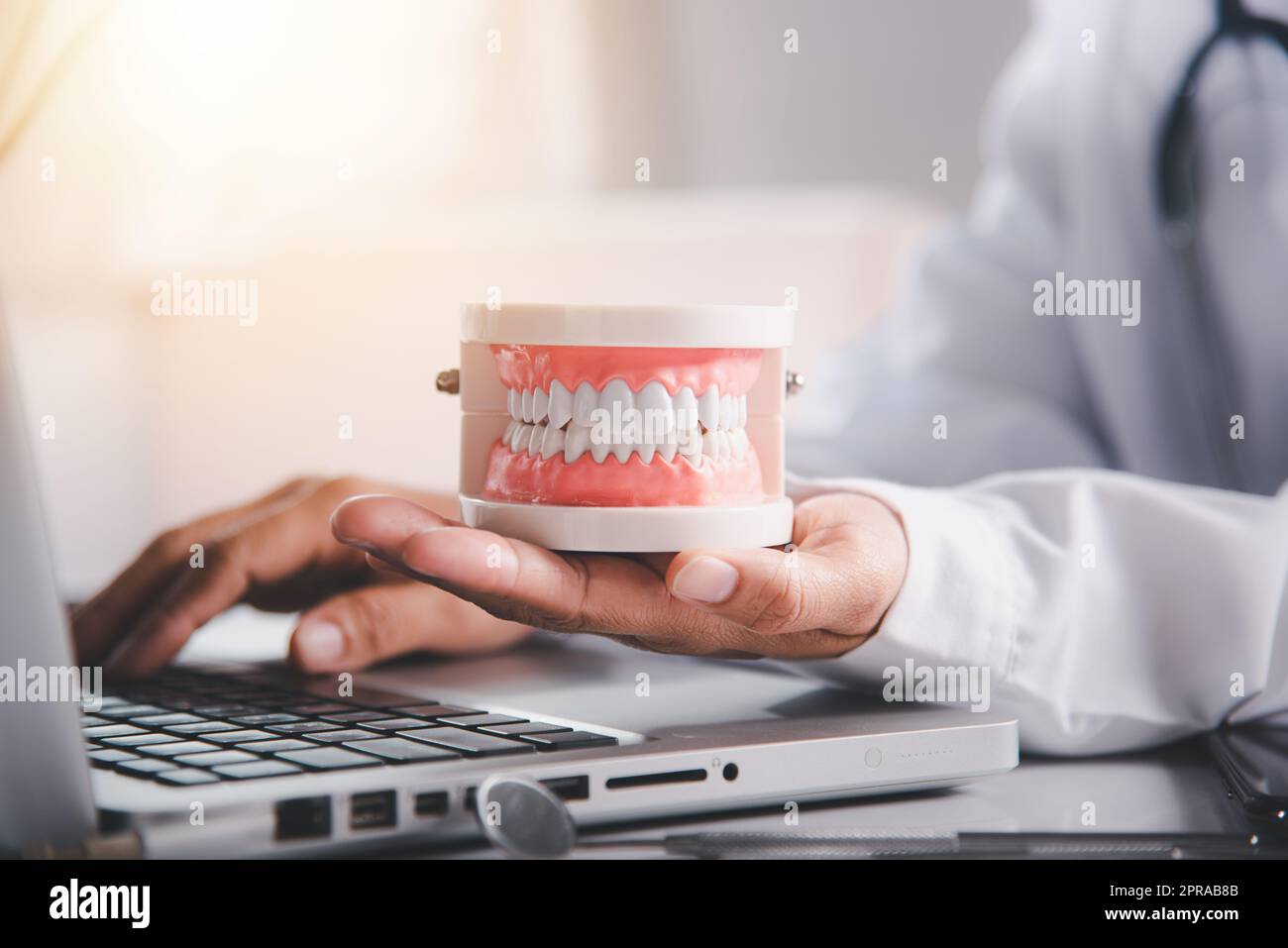Female doctor sitting and hold tooth on desk at clinic office have ...