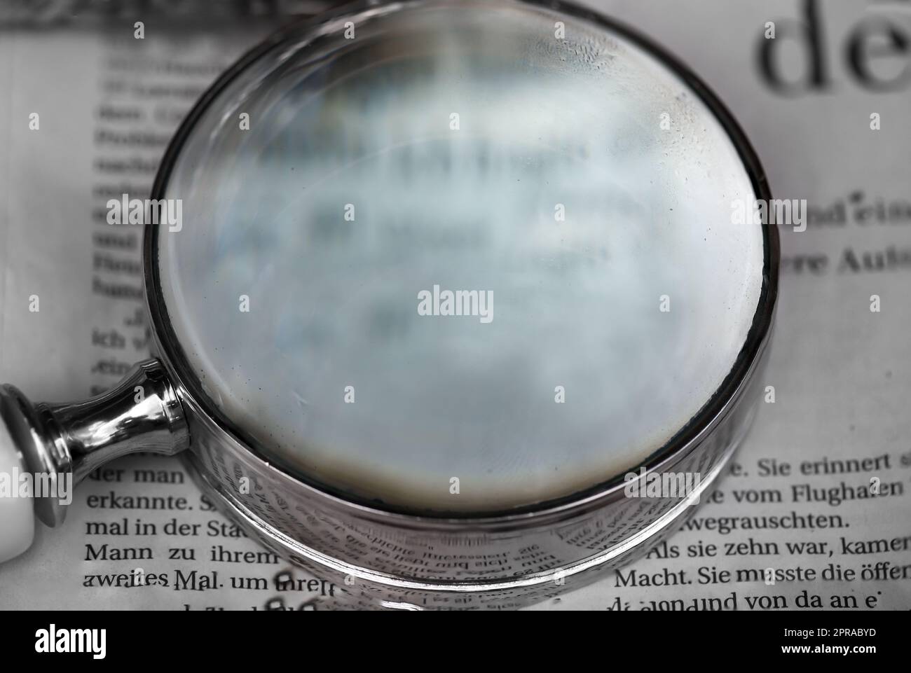 A magnifying glass, a reading aid lies on an old newspaper Stock Photo ...
