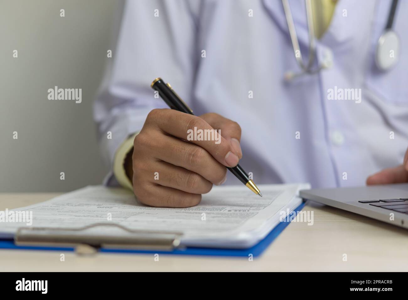 Doctor hand holding pen write and paperwork document patient treatment ...